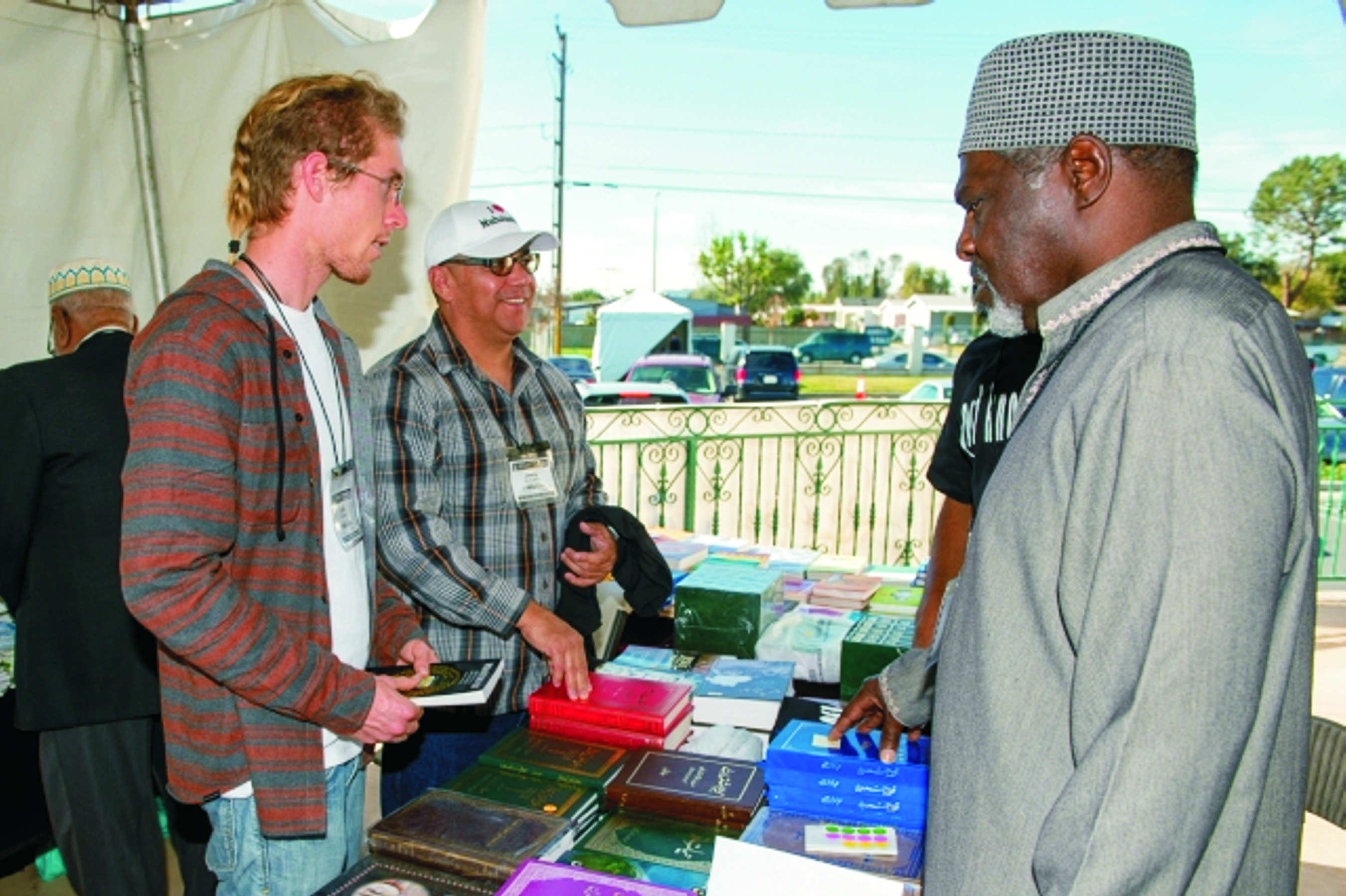 Rahman Abdul Aleem (R) mans the Ahmadiyya Muslim book stall and talks ...