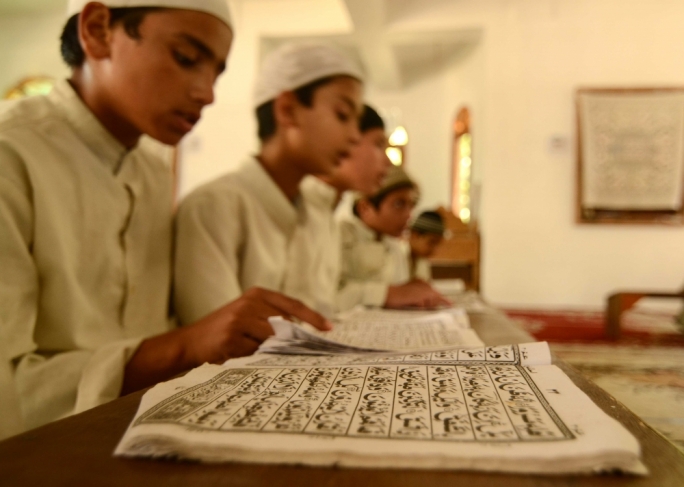 Children reciting the Quran at a religious institute. Photo does not ...
